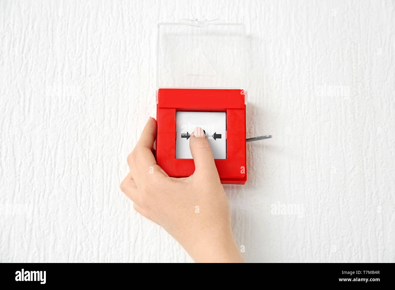 Young woman using fire alarm system indoors Stock Photo - Alamy