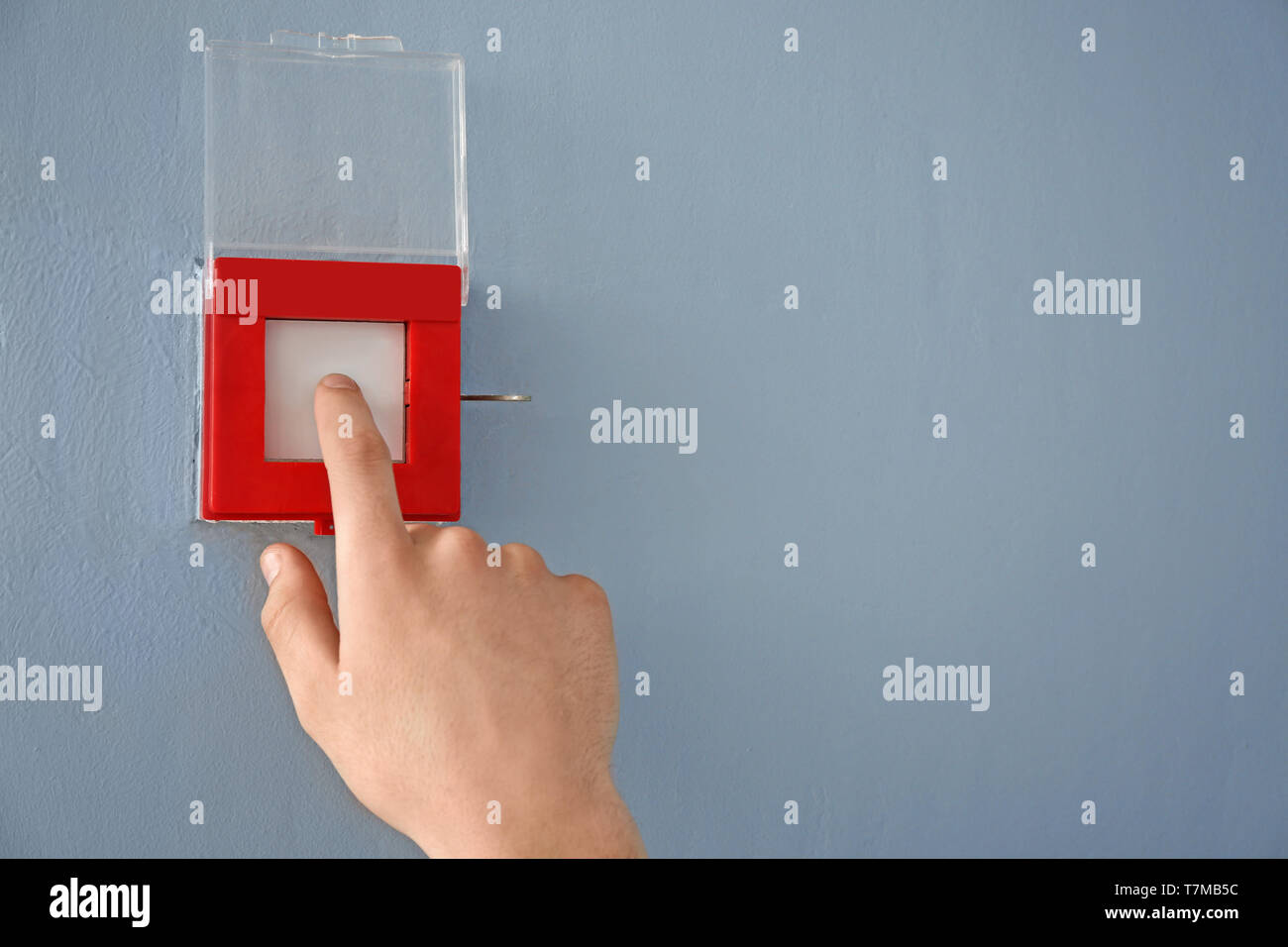 Young man using fire alarm system indoors Stock Photo - Alamy