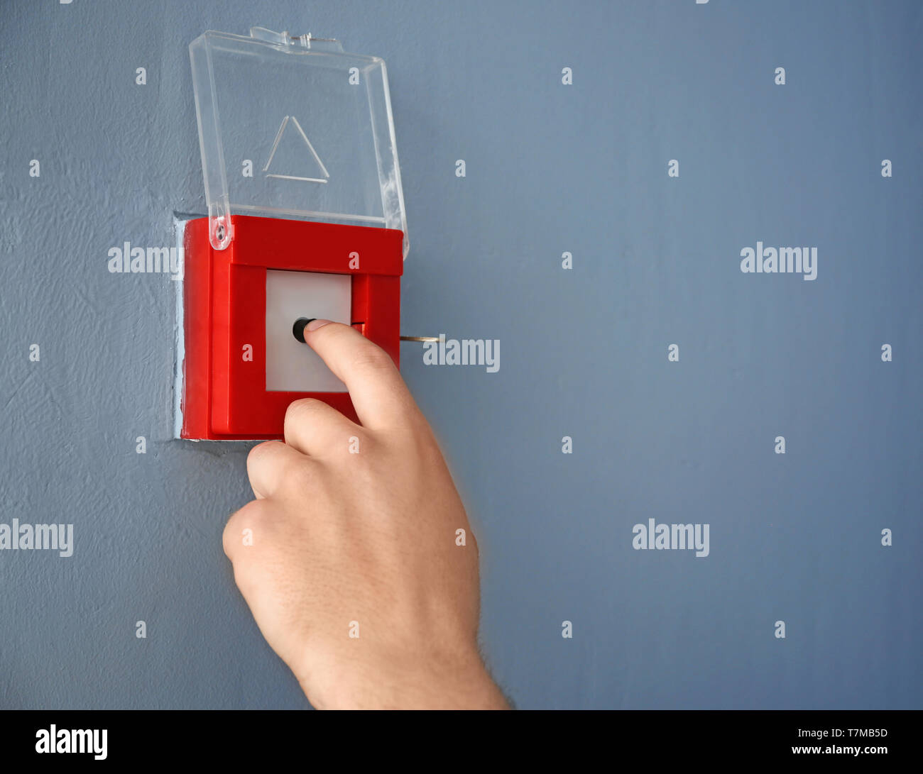 Young man using fire alarm system indoors Stock Photo - Alamy