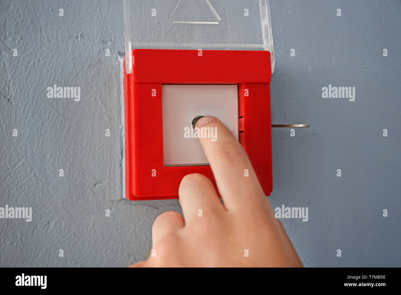 Young man using fire alarm system indoors Stock Photo - Alamy