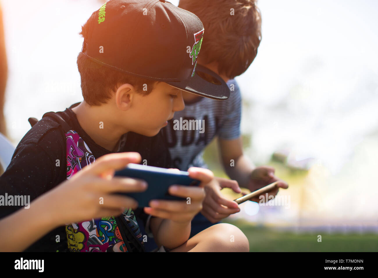 Little boy child playing mobile games on smartphone in the park Stock ...