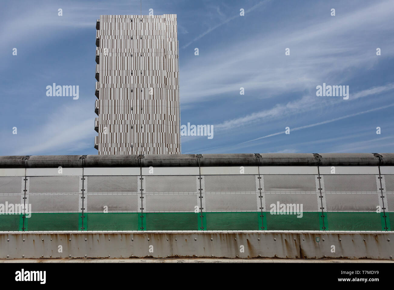 An apartment building towers over the sound-proofing walls on an ...