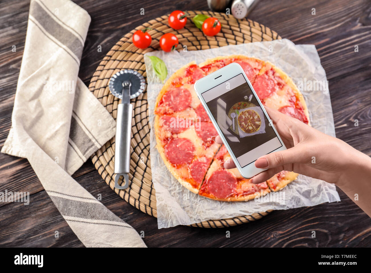 Woman photographing pepperoni pizza with mobile phone Stock Photo - Alamy