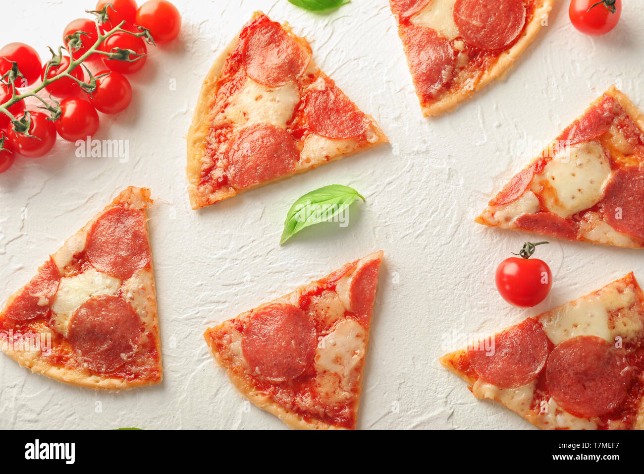 Pieces of pepperoni pizza on light background Stock Photo - Alamy