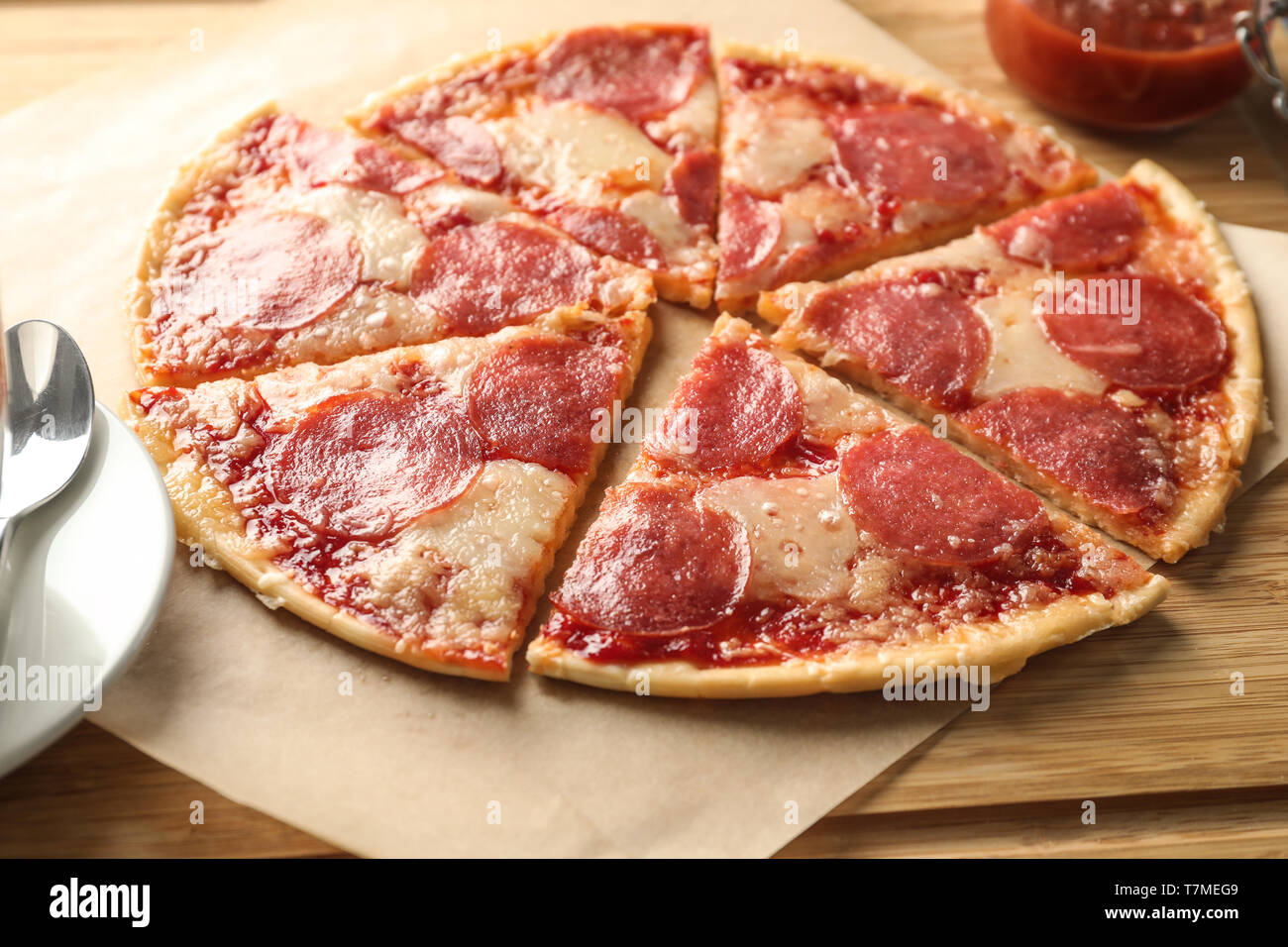 Wooden board with pieces of pepperoni pizza on table Stock Photo - Alamy