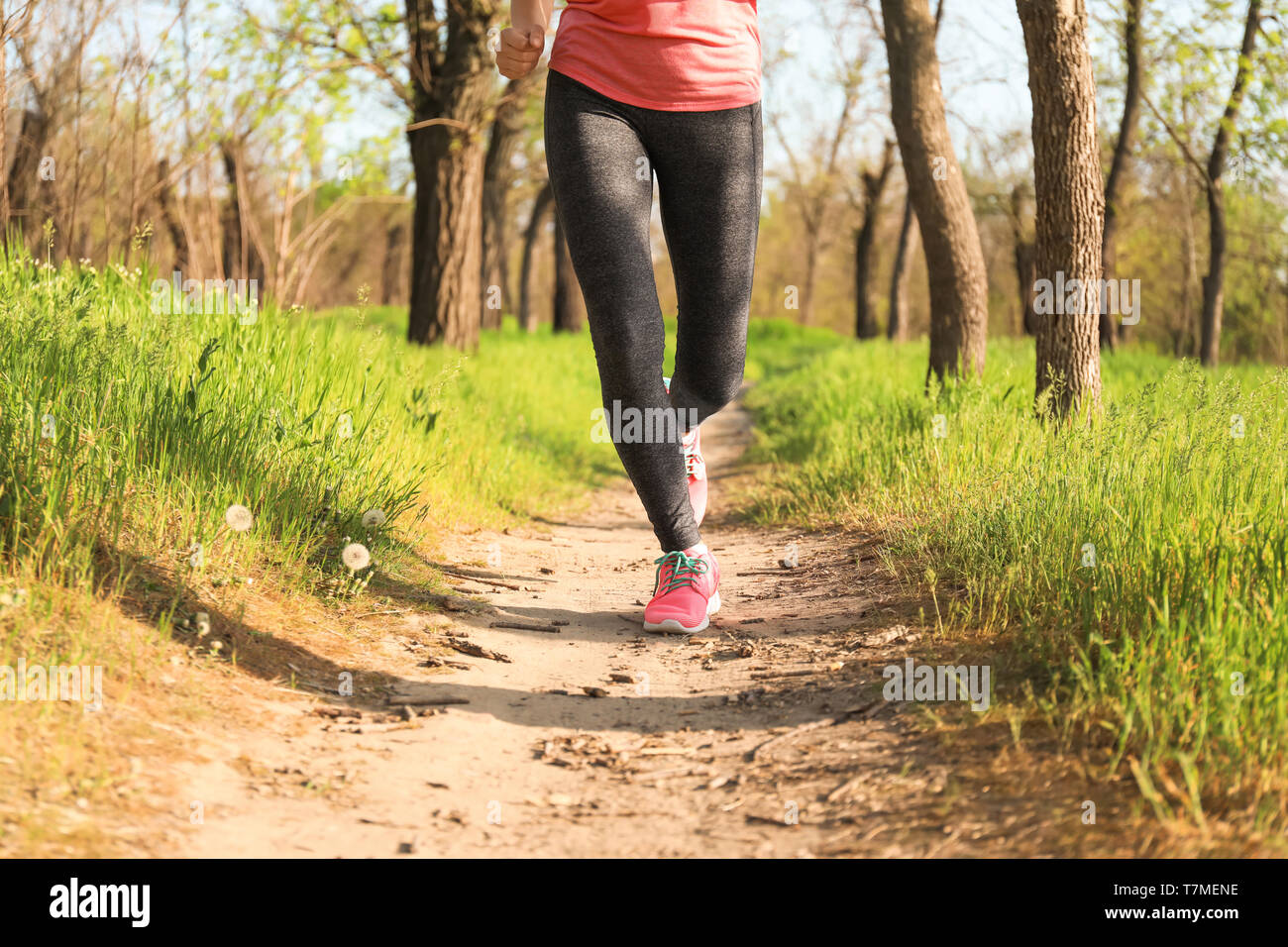 Sporty young woman running in park Stock Photo - Alamy