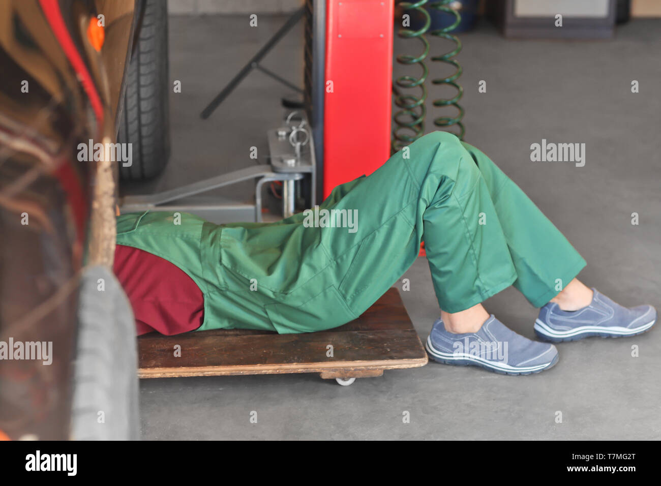 Mechanic under car legs hi-res stock photography and images - Alamy