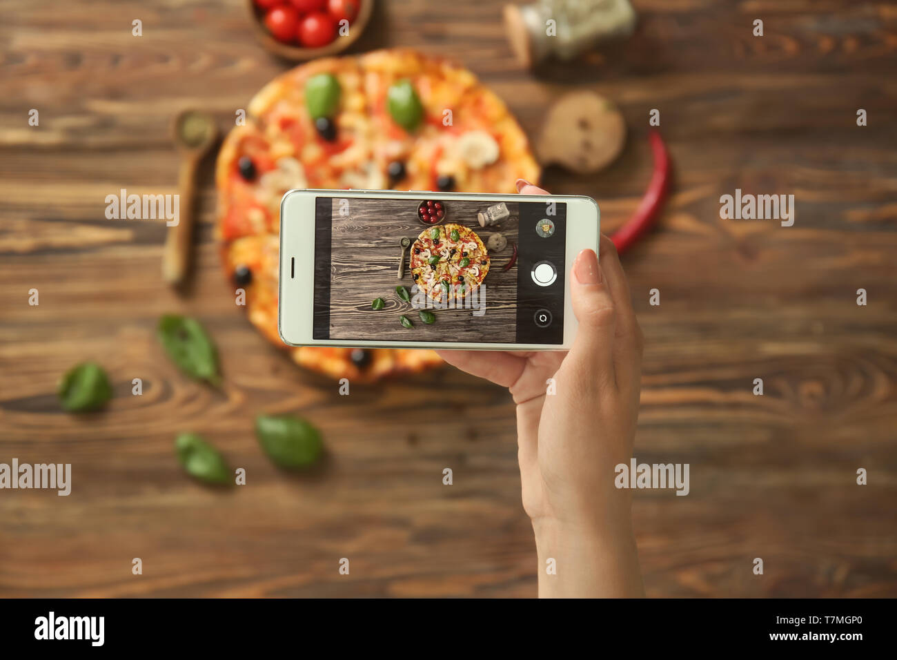 Woman taking photo of delicious Italian pizza with mobile phone Stock ...