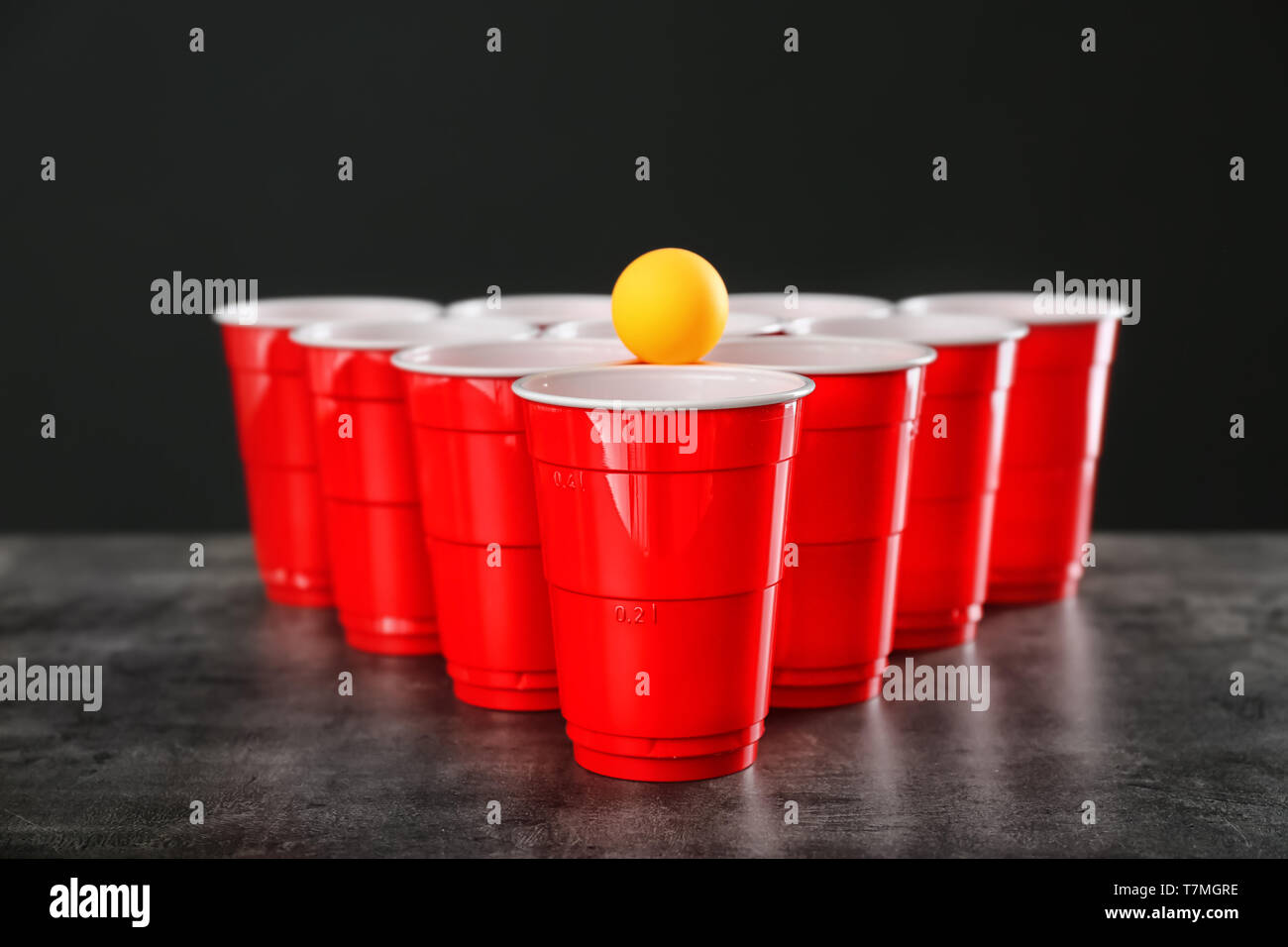Cups and ball for beer pong on table Stock Photo - Alamy