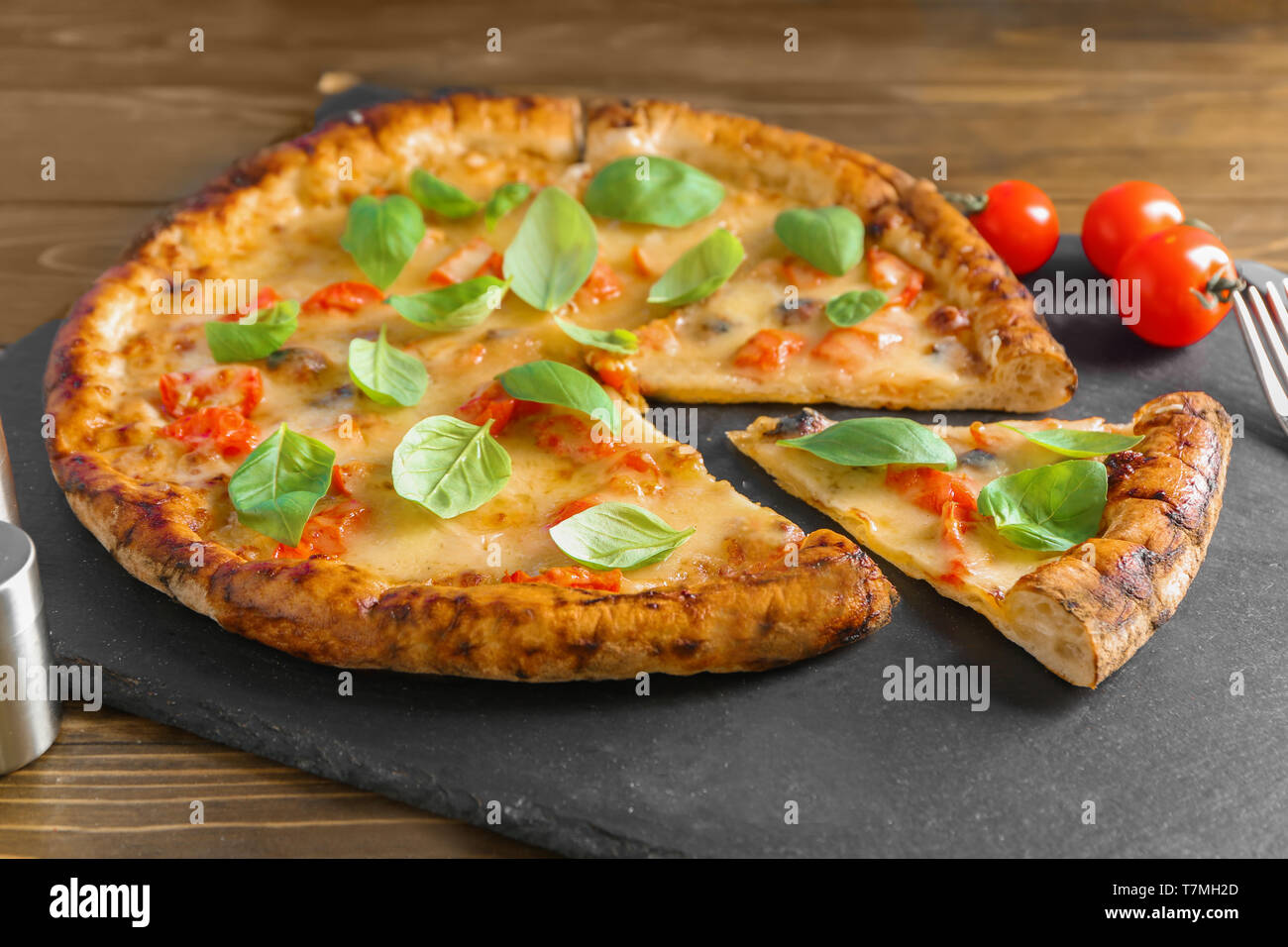 Slate plate with delicious pizza Margherita on table Stock Photo - Alamy