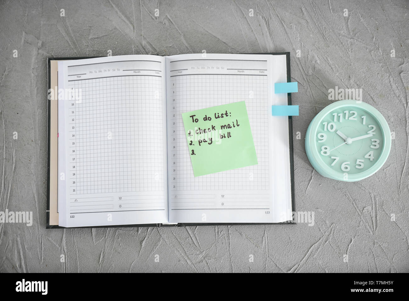 To-do list and clock on textured background Stock Photo - Alamy