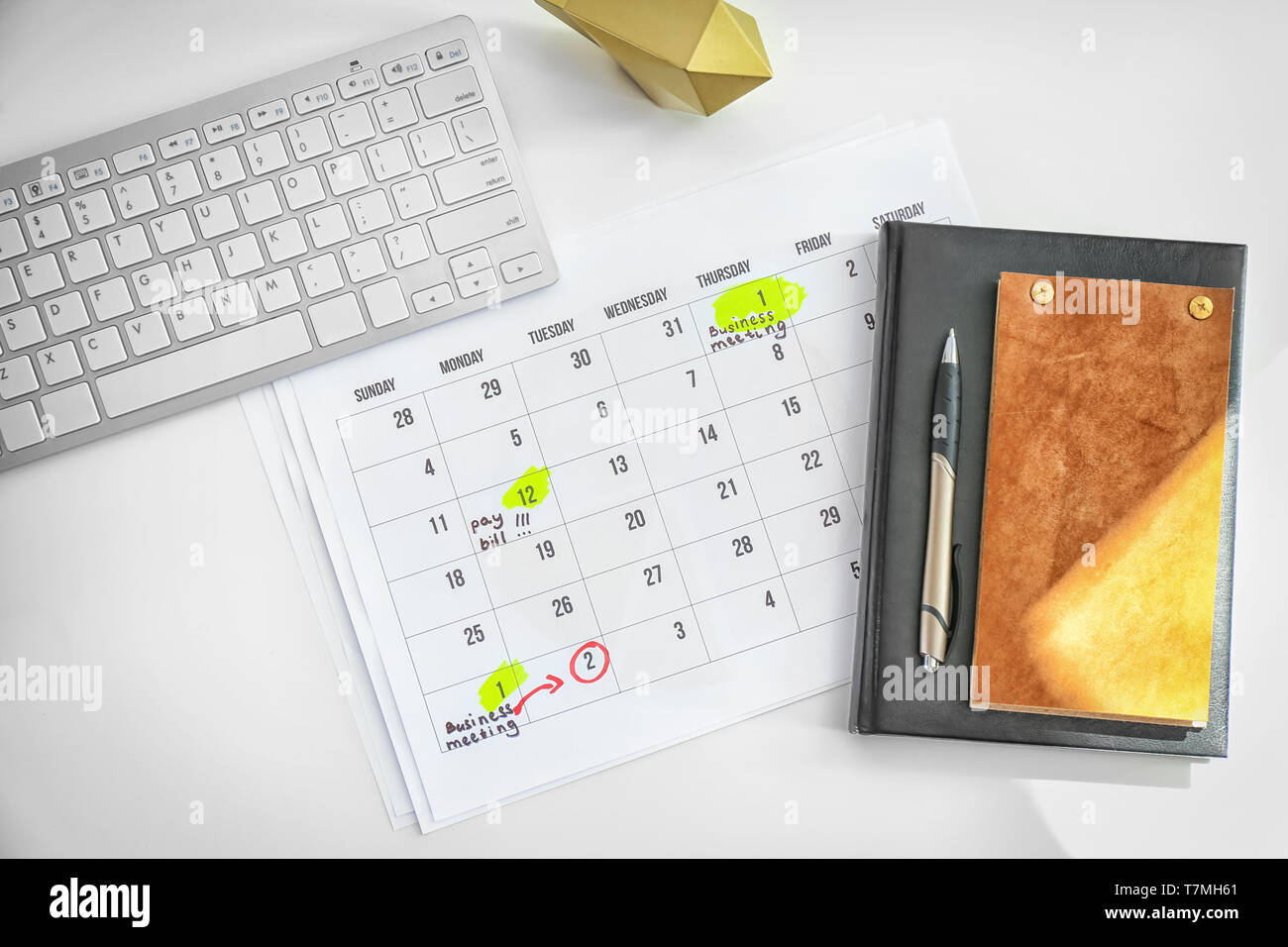 Calendar with notes, computer keyboard and notebooks on white ...