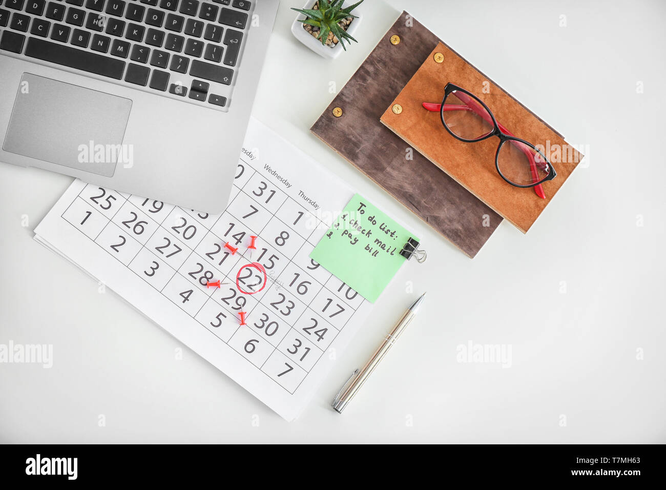 Calendar with notes and laptop on white background Stock Photo - Alamy