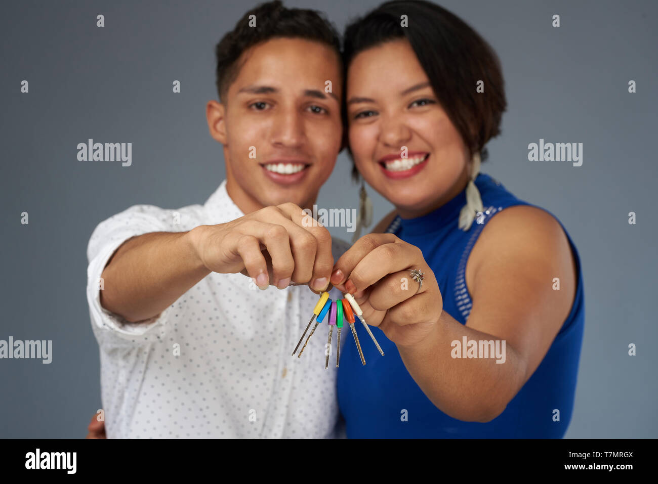 Set of colorful home keys holding young couple Stock Photo - Alamy