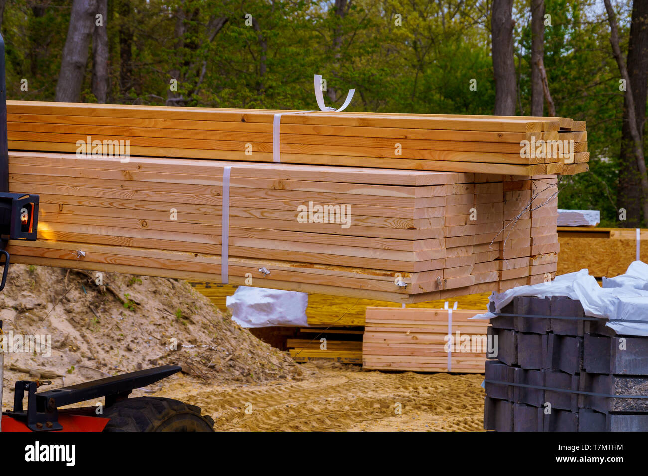 Lift truck moving a stack of 2 x 4 lumber studs at a small log ...