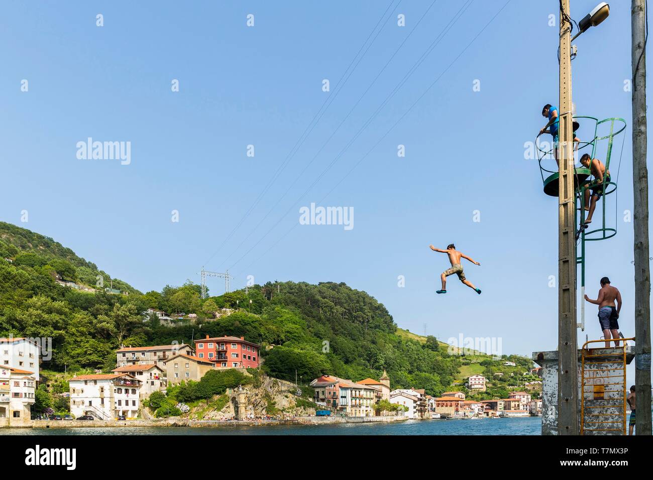 Spain, Guipuzkoa, Bask Country, Pasaia, Young people dive and bathe in ...
