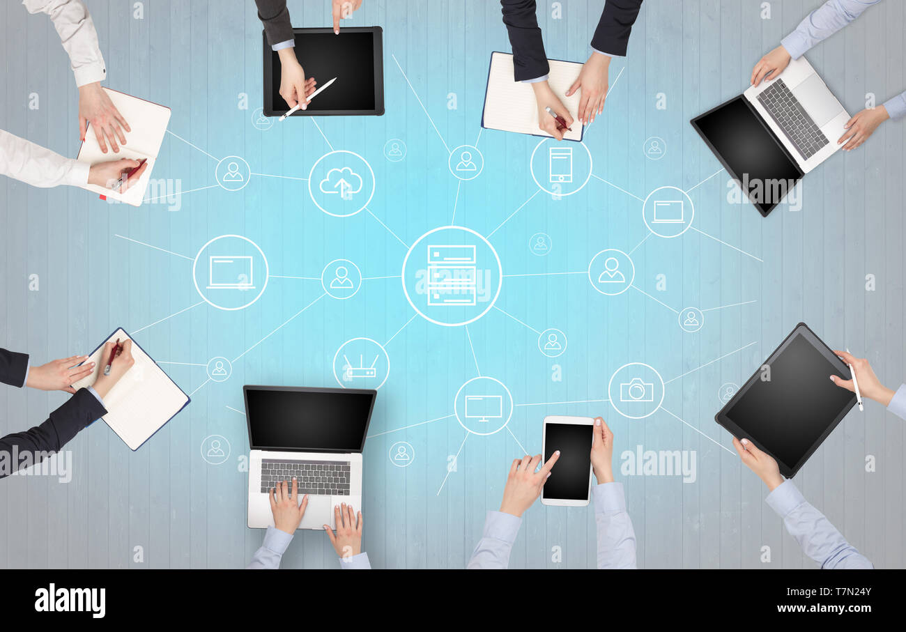 Group of people with devices in hands working in team on tablets ...