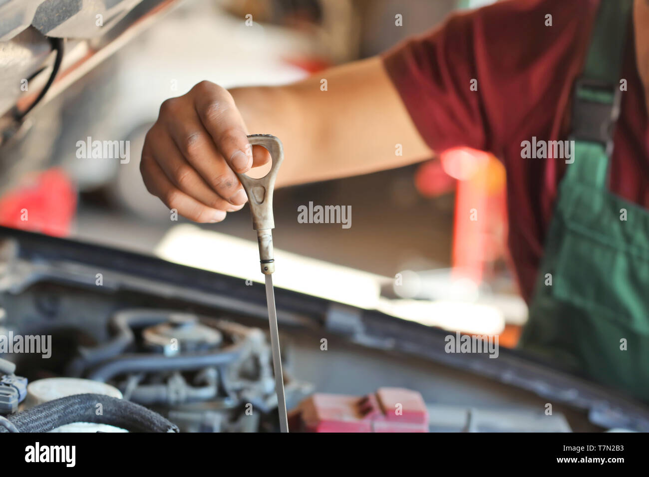 Male mechanic checking level of oil in car engine Stock Photo - Alamy