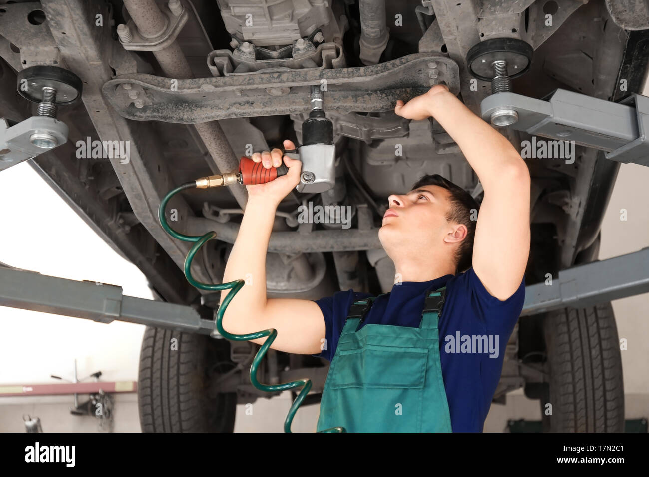 Male mechanic fixing car in service center Stock Photo - Alamy