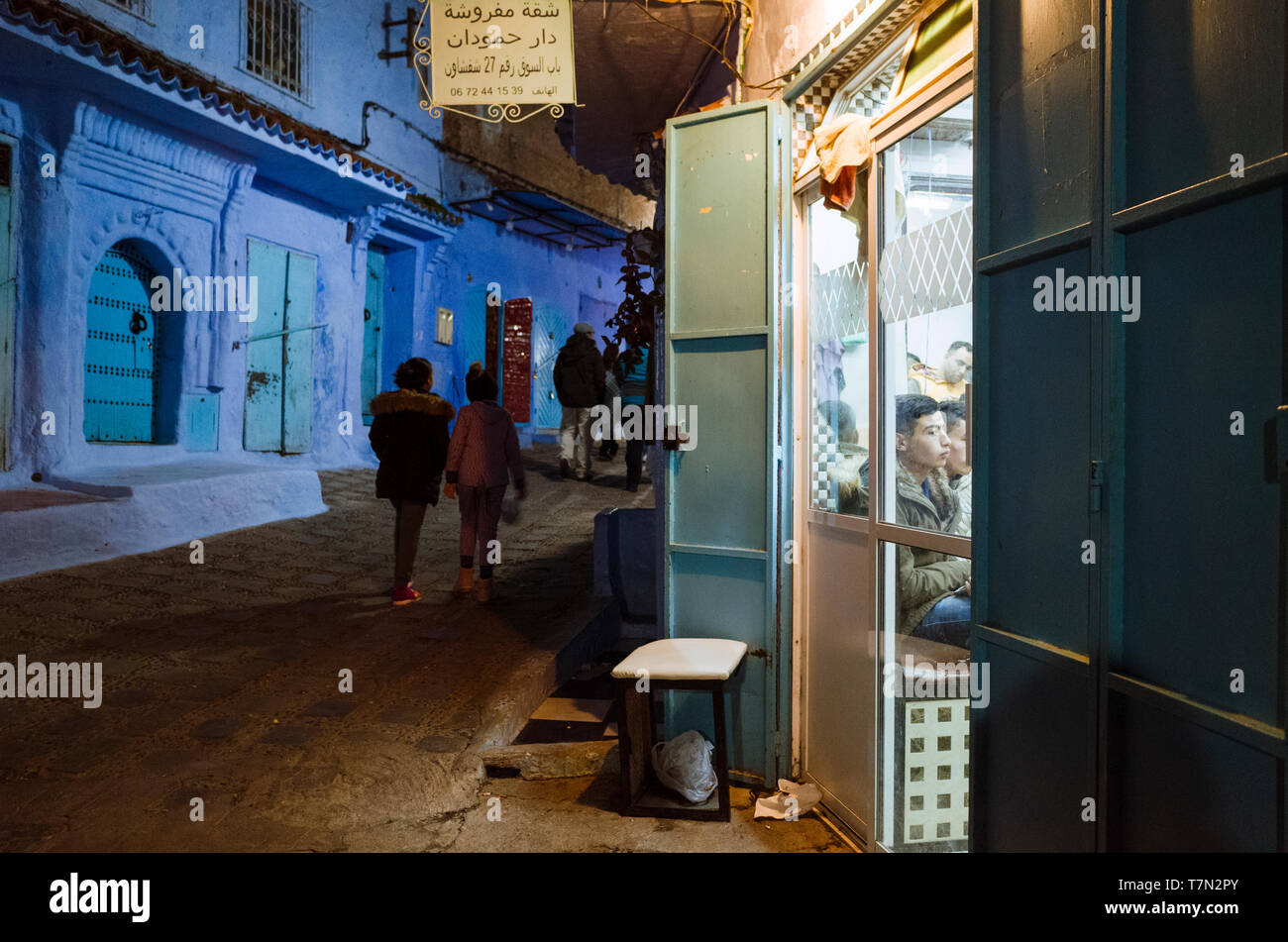Chefchaouen, Morocco : People walk past an illuminate barber shop at ...