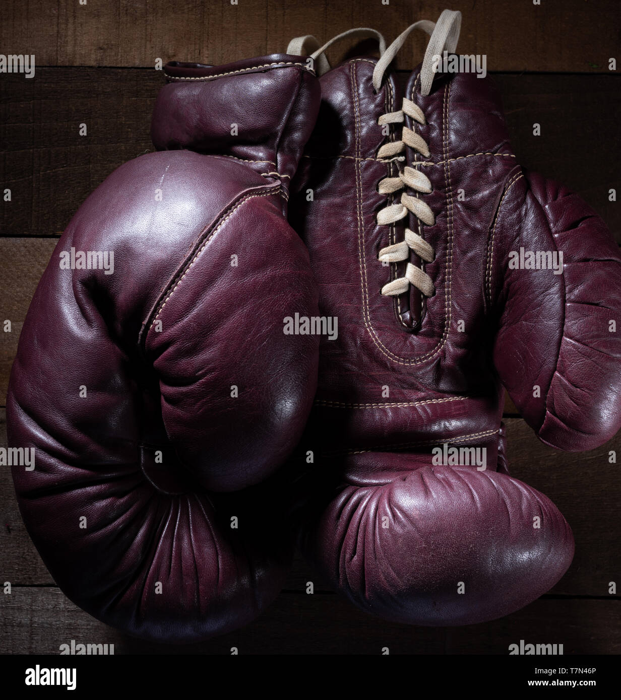 Pair of vintage, antique boxing gloves on a brown, slat wooden ...