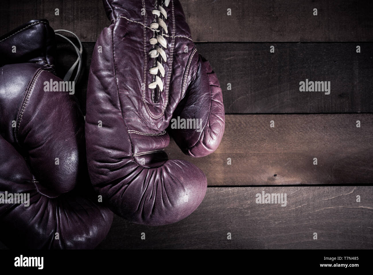 Pair of vintage, antique boxing gloves on a brown, slat wooden ...