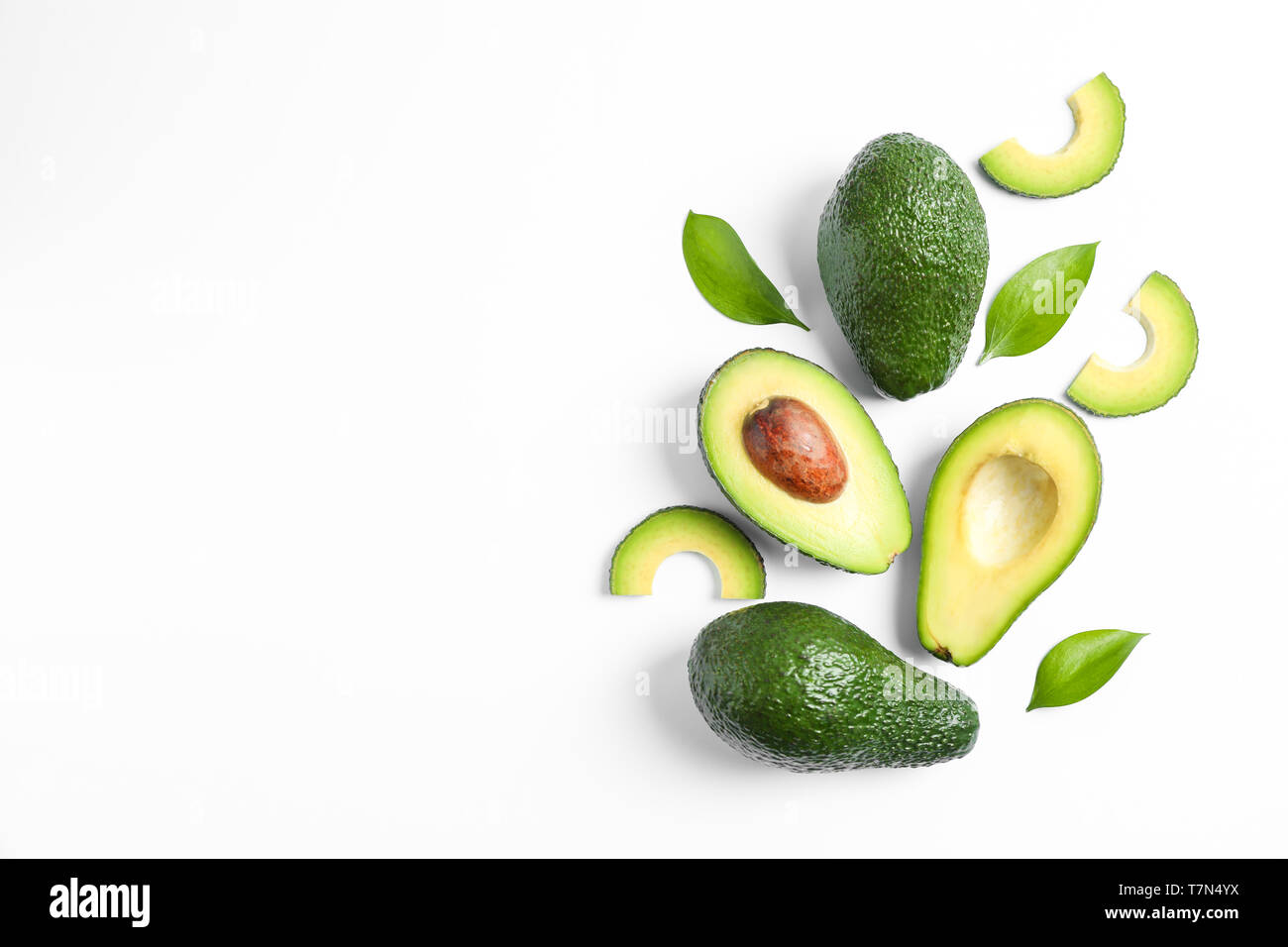 Flat lay composition with ripe avocados and leaves on white background ...