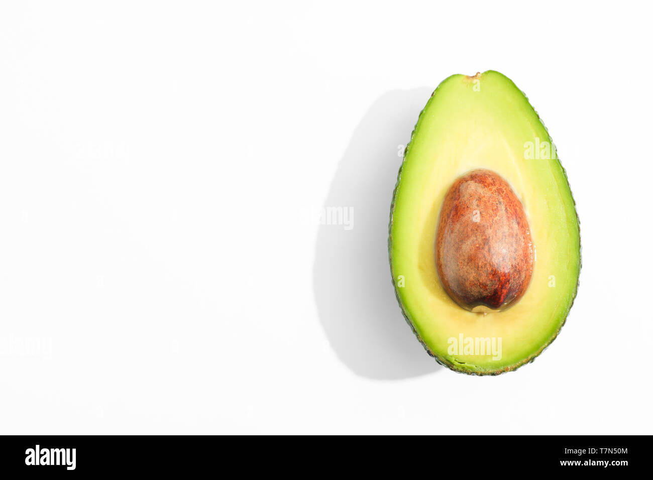 Rip cut avocado on white background, space for text Stock Photo - Alamy