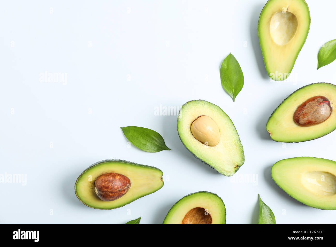 Flat lay composition with ripe avocados on white background, space for ...