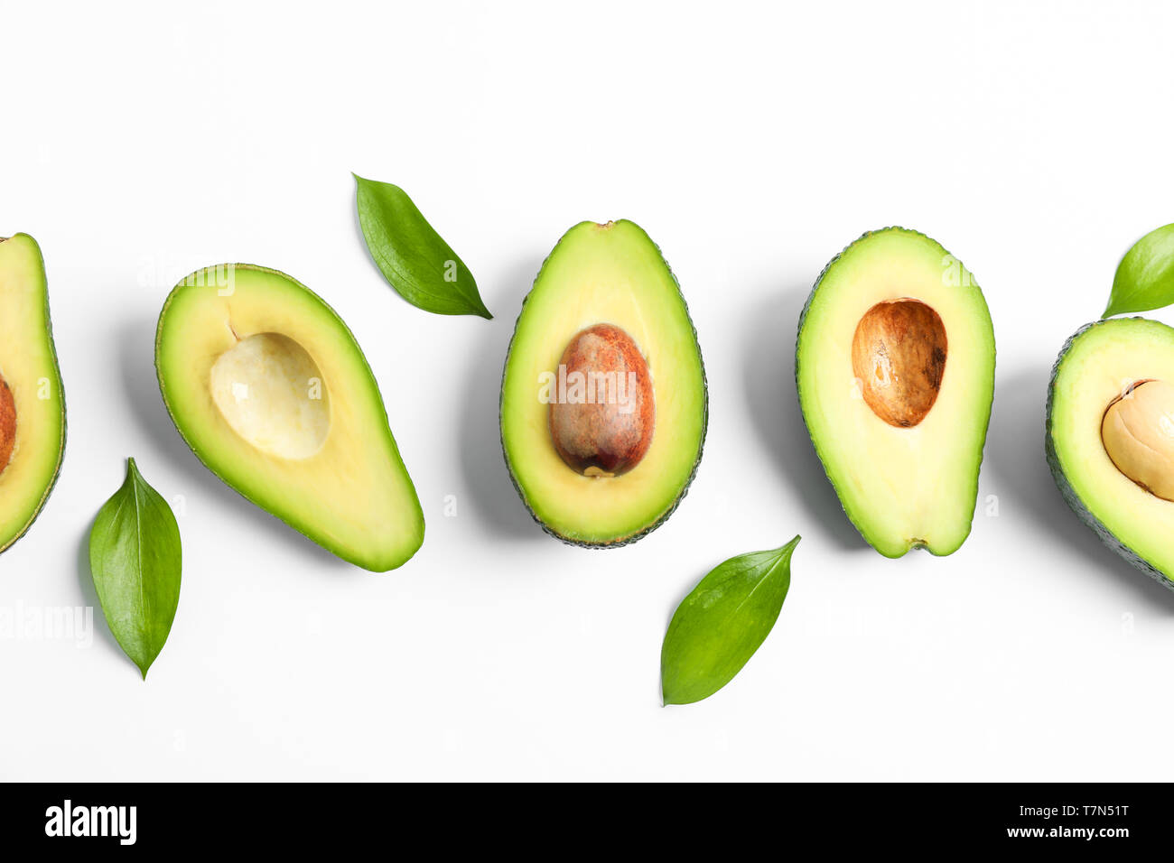 Flat lay composition with ripe avocados and leaves on white background ...