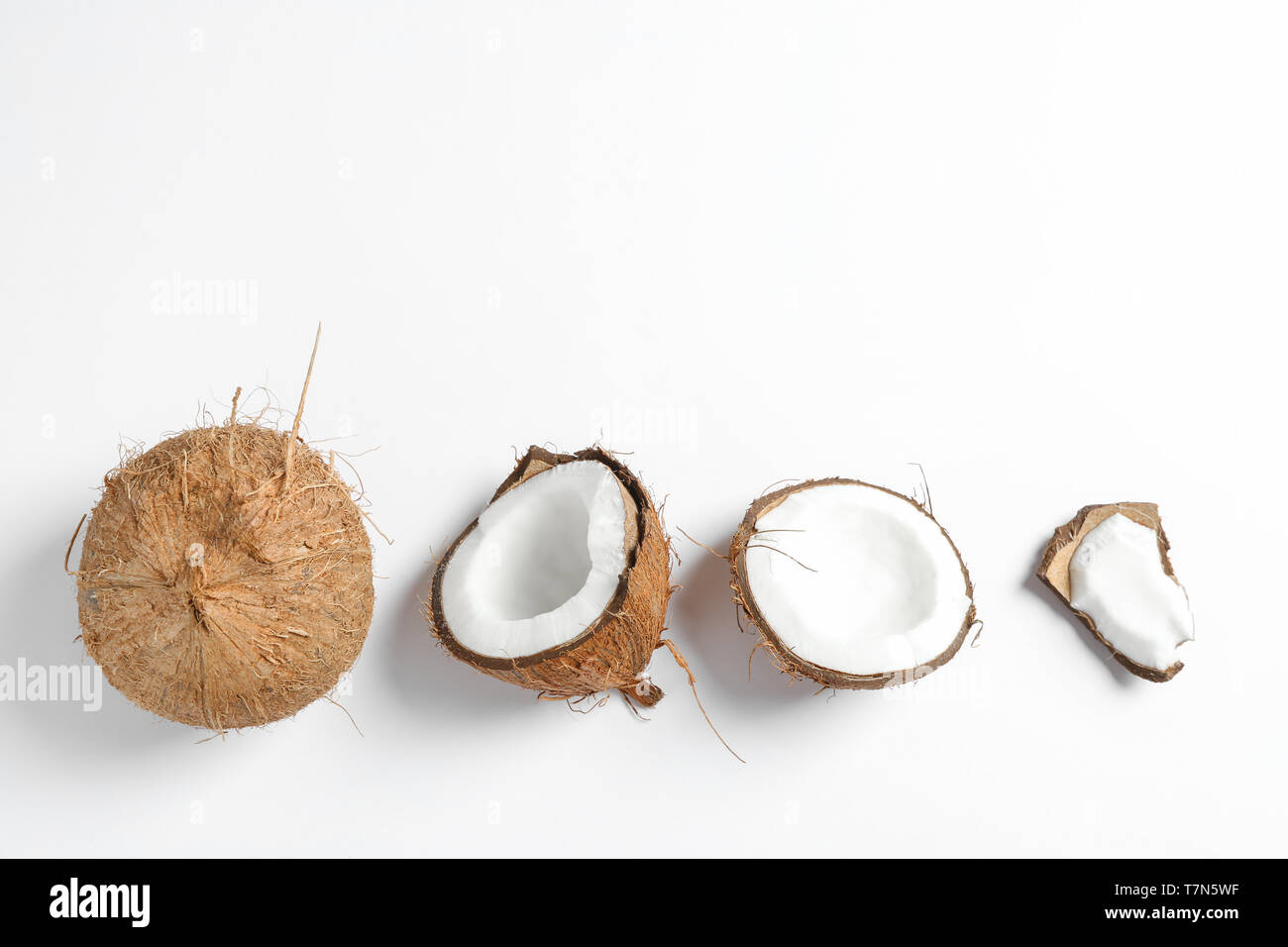 Two coconut one of which split on white background Stock Photo - Alamy
