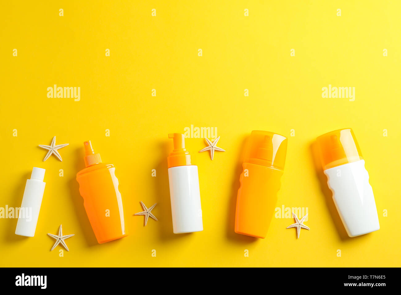 Flat lay composition with sunscreen sprays and starfishes on color ...