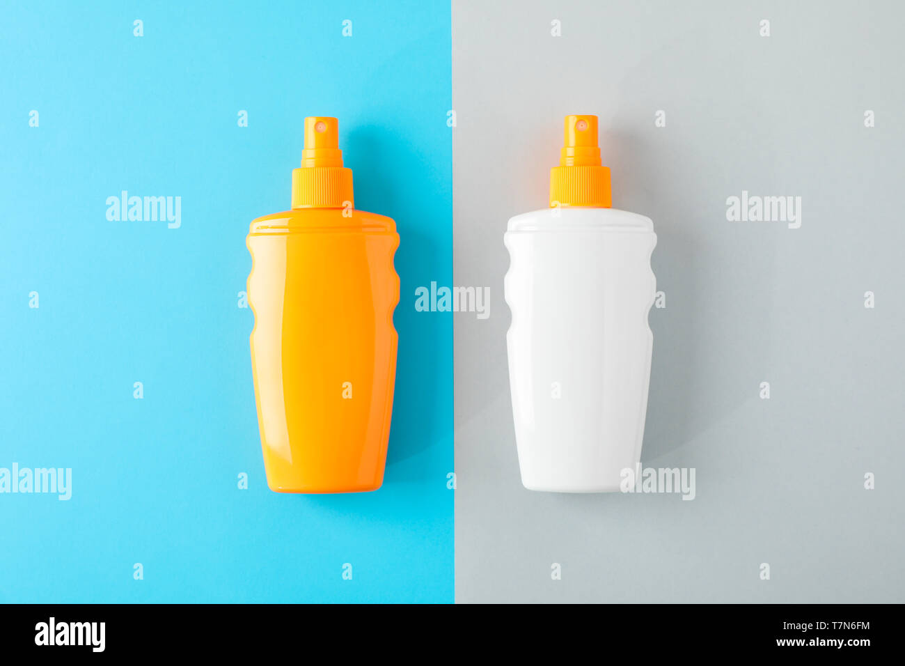 Composition with sunscreen sprays on two tone background. Space for ...