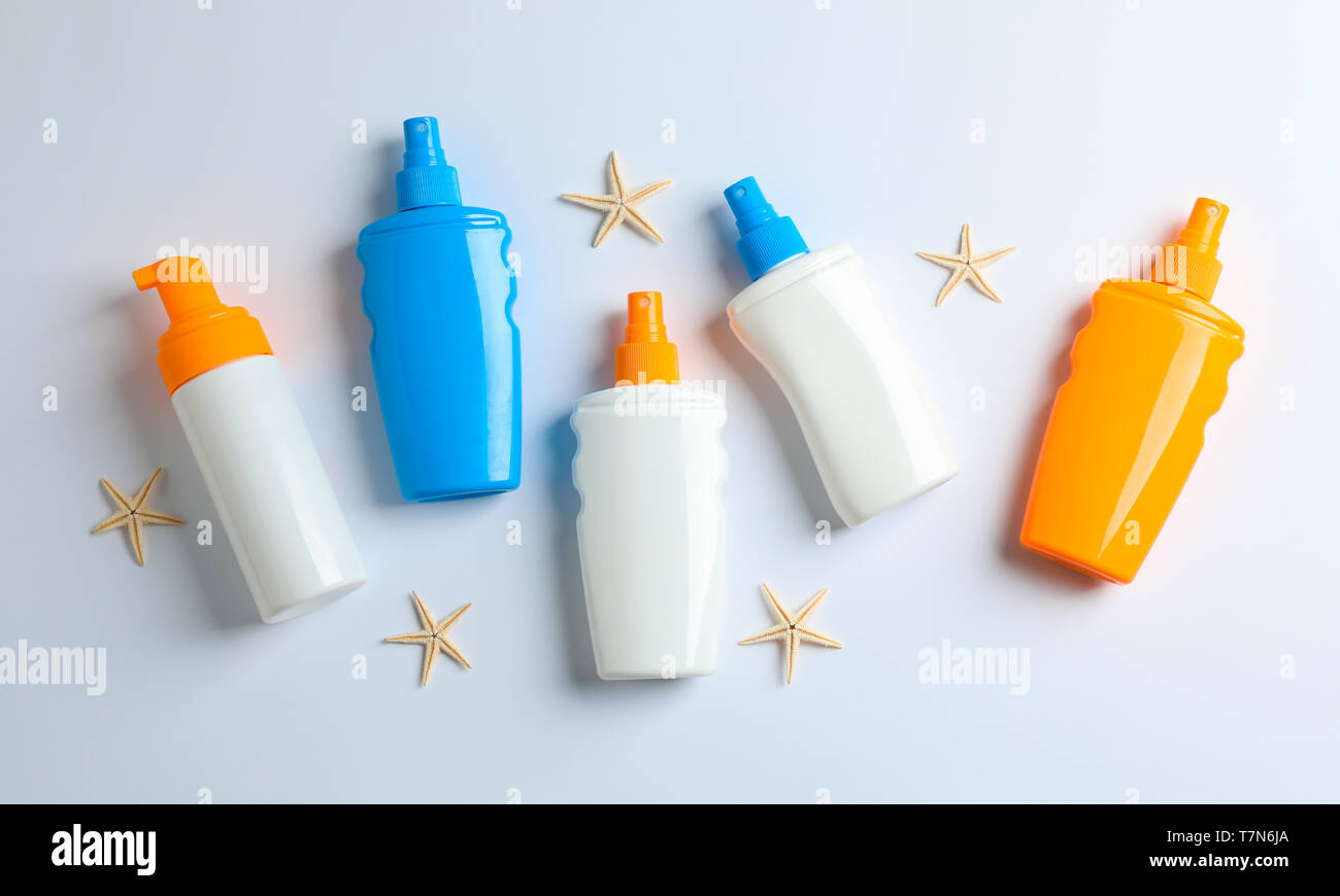 Flat lay composition with sunscreen sprays and starfishes on color ...