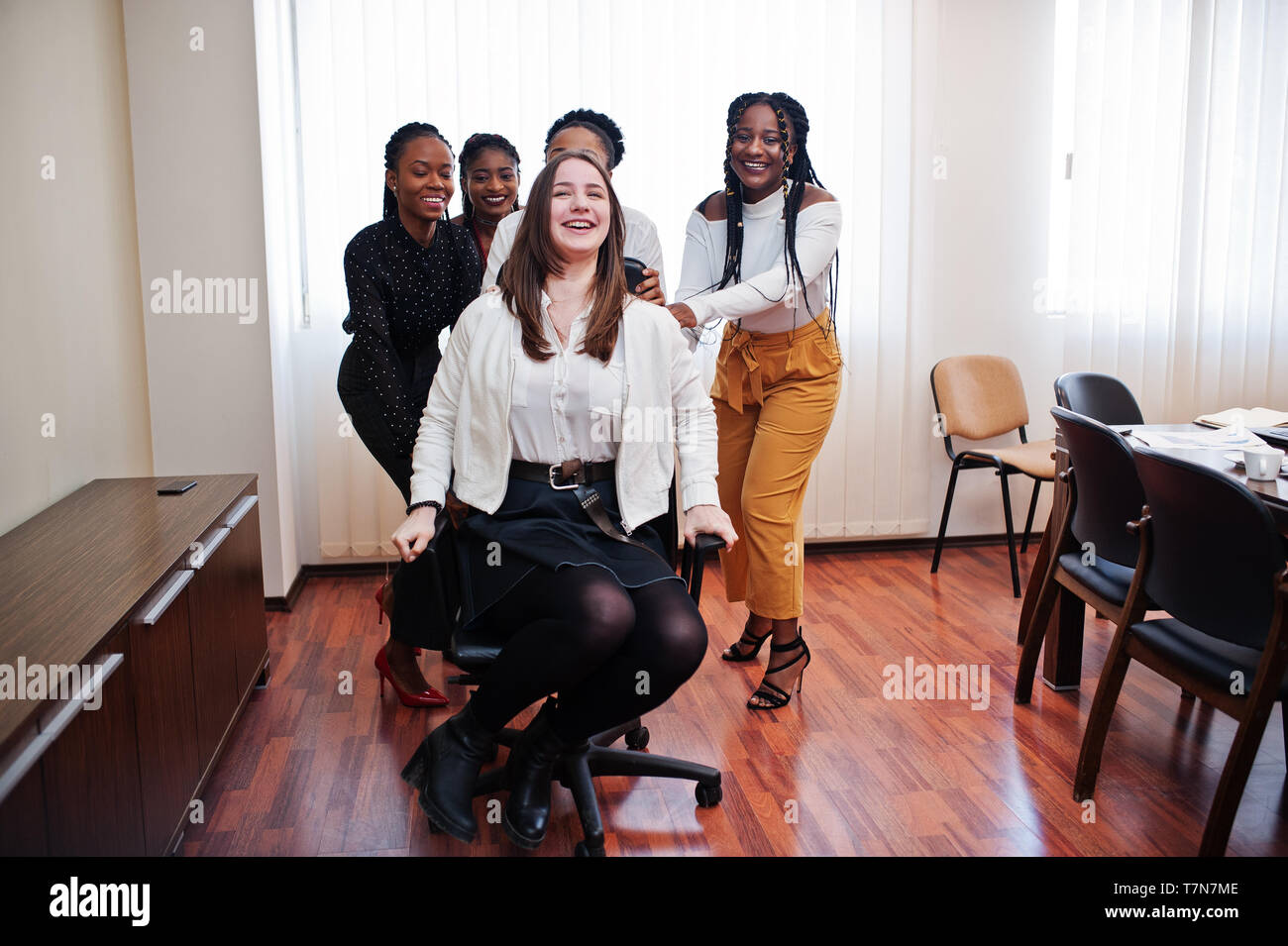 Five multiracial business womans standing at office and roll woman on ...