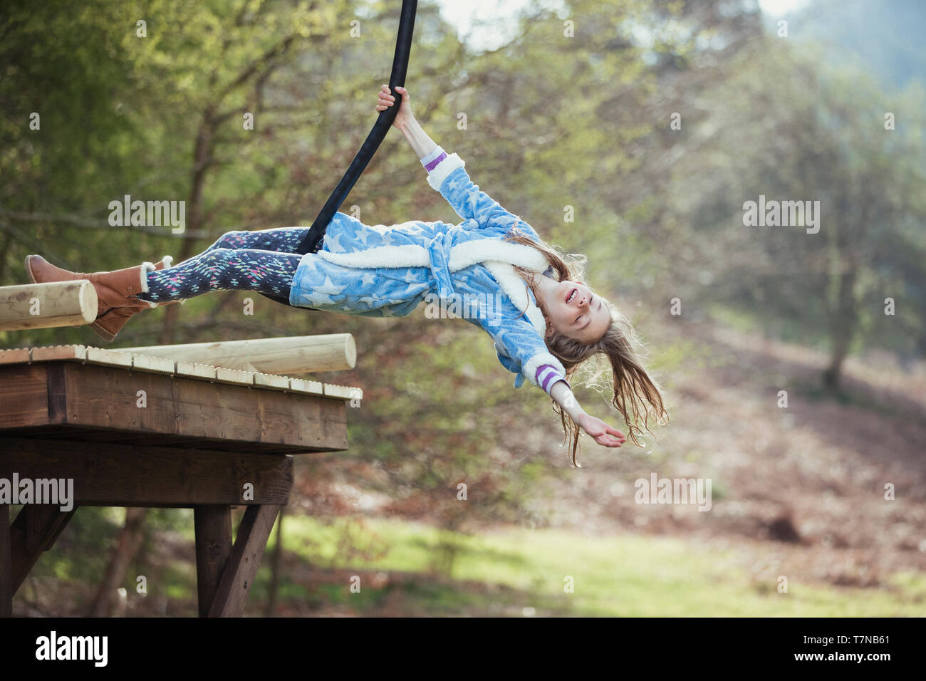 Little girl is pushing herself off the monkey swing platform with her ...