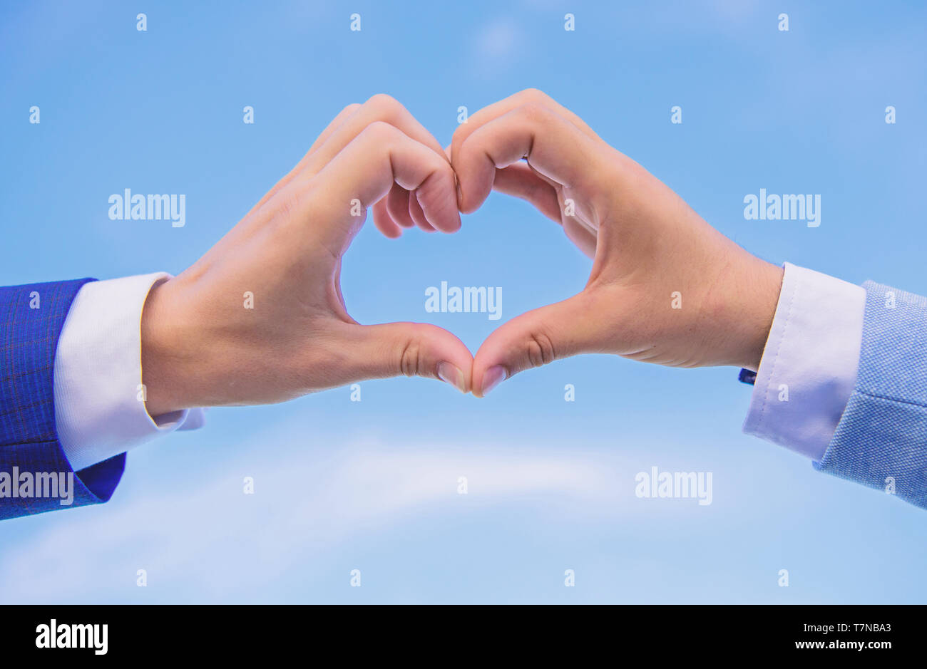 Love symbol concept. Hands put together in heart shape blue sky ...