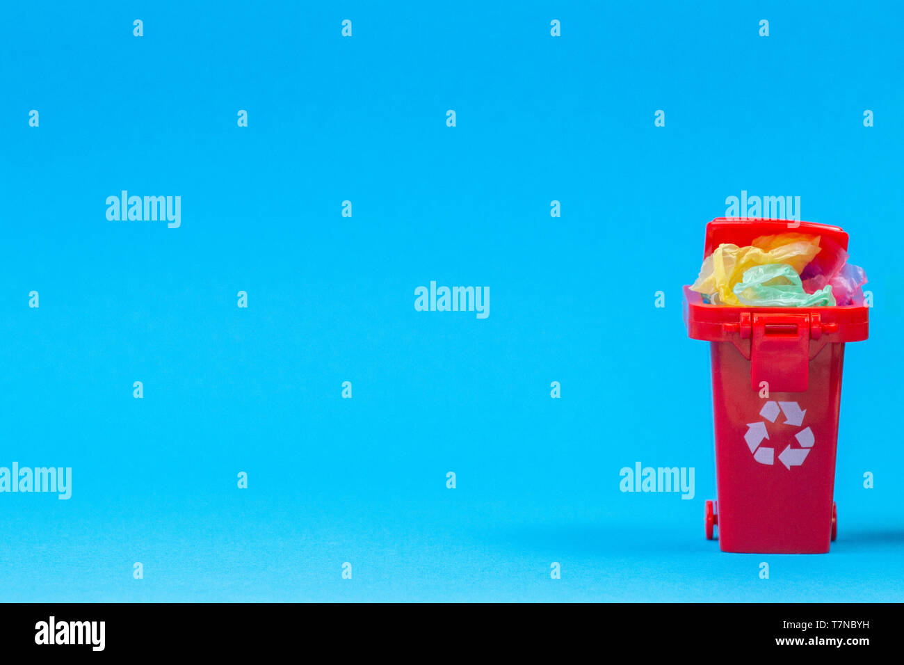 Red recycle bins container with plastic garbage on blue background ...