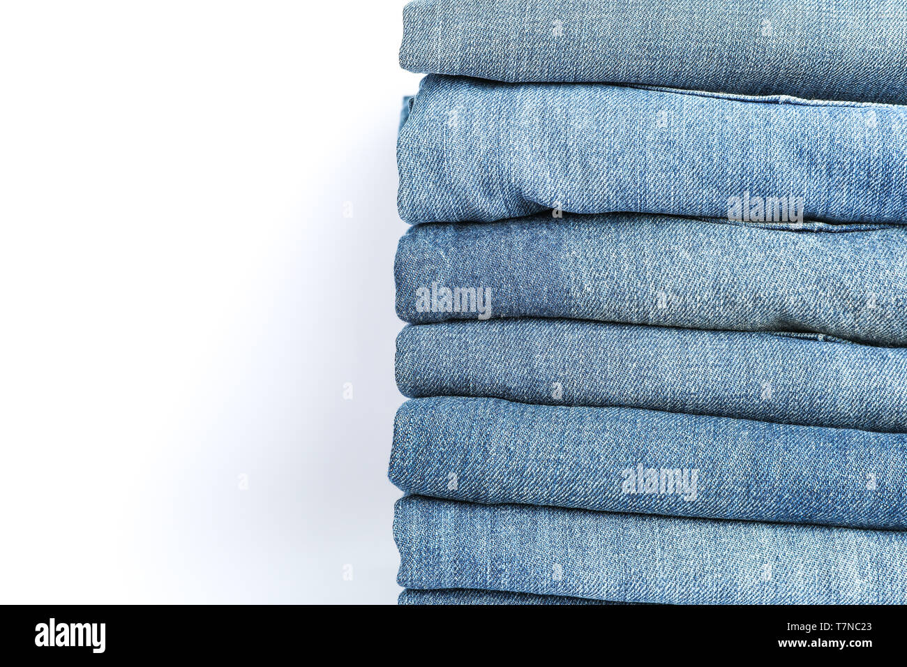 Stack of blue jeans on white background, space for text Stock Photo - Alamy
