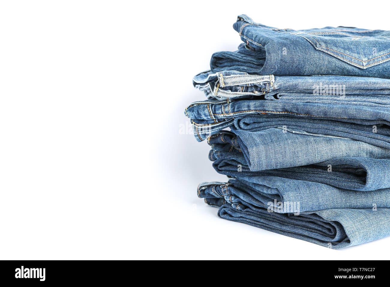 Stack of blue jeans on white background, space for text Stock Photo - Alamy