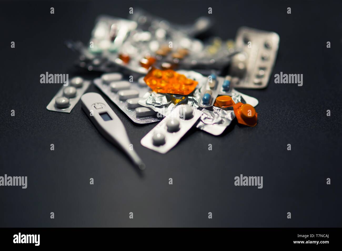 different types of drugs and a thermometer - isolated on a black ...