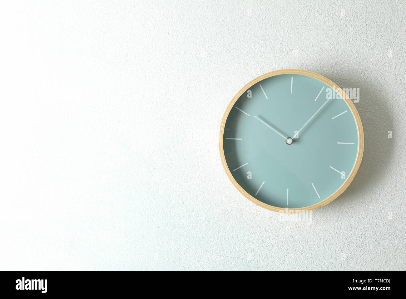 Big beautiful stylish clock hanging on light background, space for text ...