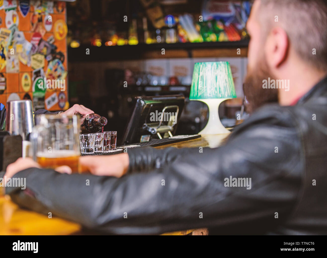 Man spend leisure in dark pub. Man sit at bar counter in pub. Weekend ...