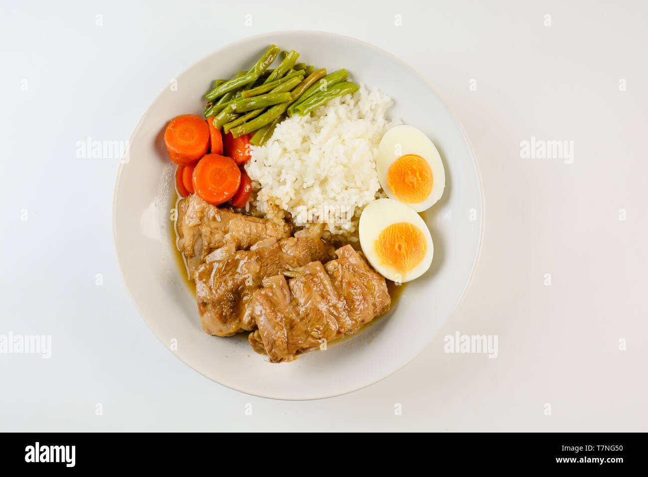 Baked pork ribs with rice, boiled egg and vegetable Stock Photo - Alamy