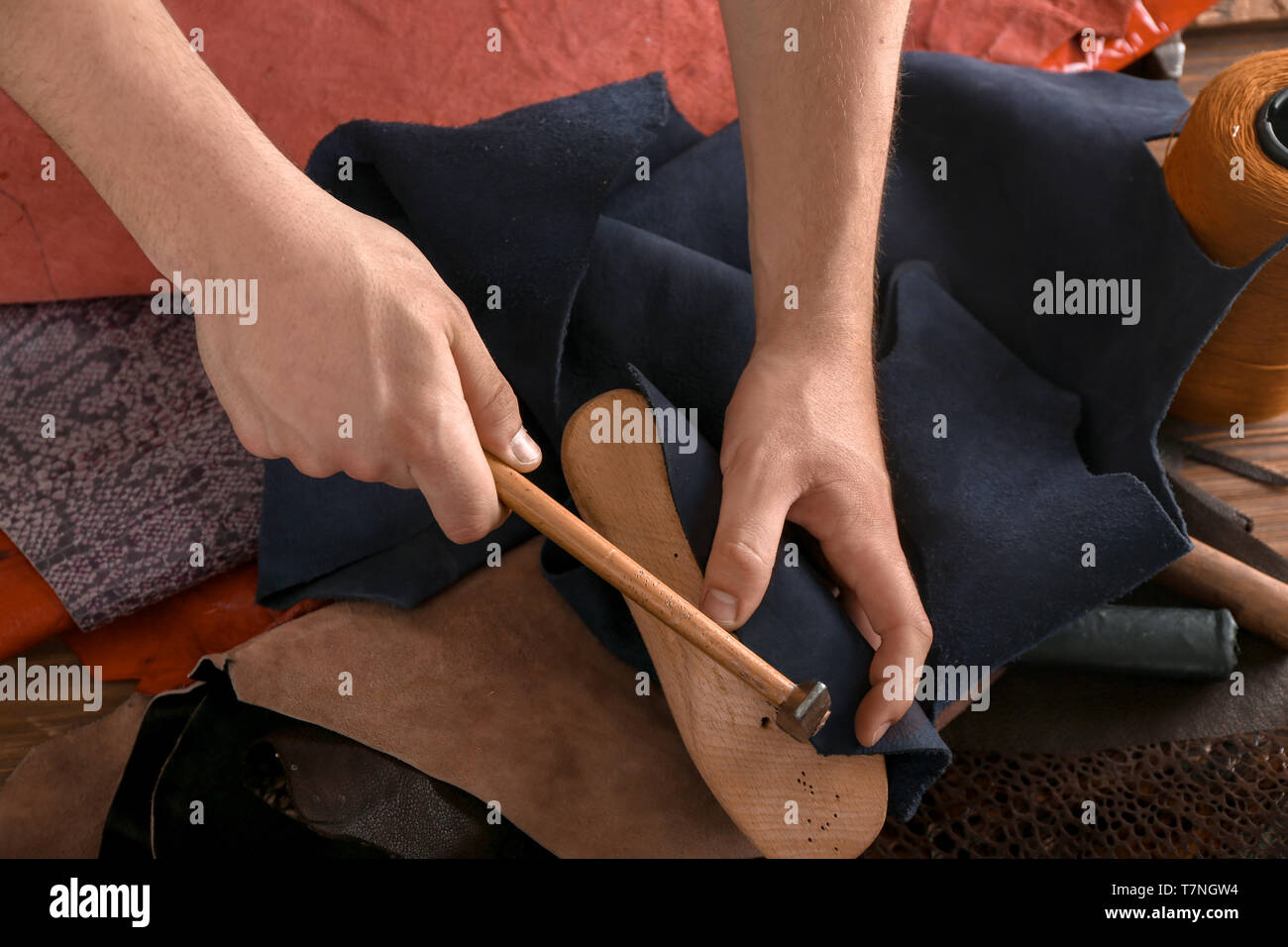Shoemaker working with shoe-tree and hammer at factory Stock Photo - Alamy
