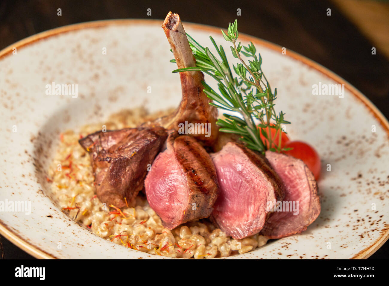 Shredded meat dish with garnish decorated with vegetables on a white ...
