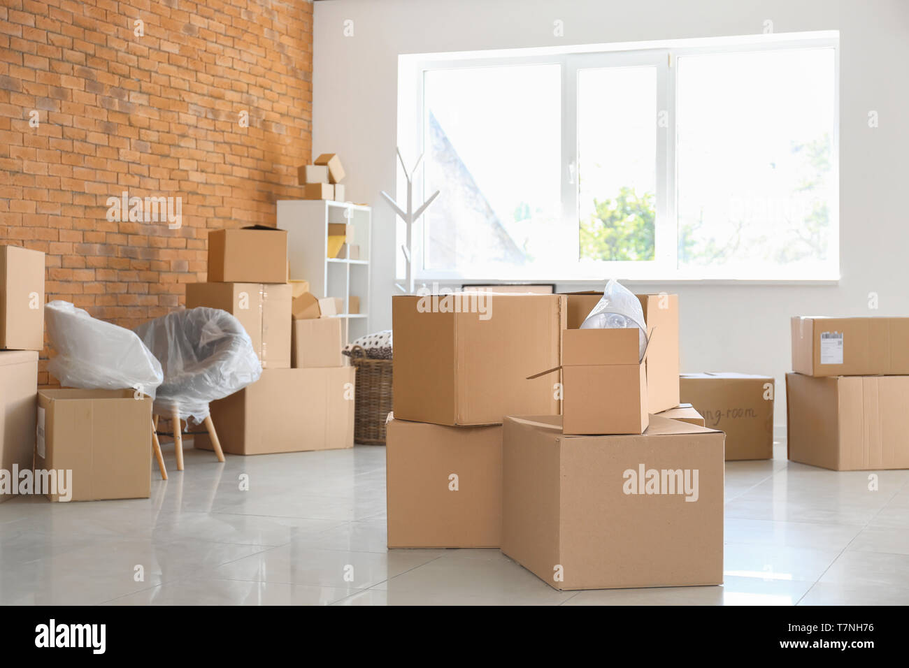 Carton boxes and interior items in room. Moving house concept Stock ...