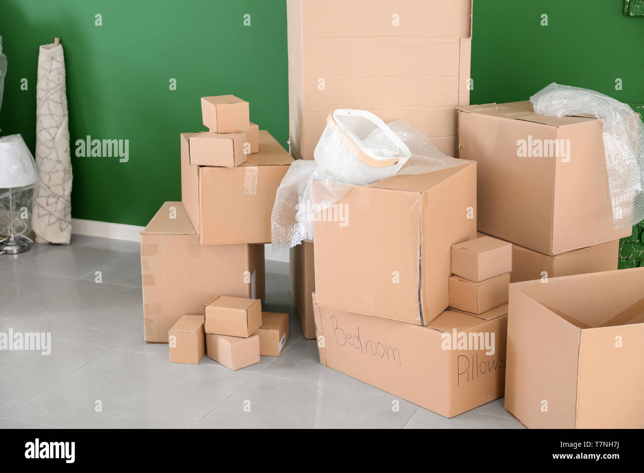 Carton boxes and interior items in room. Moving house concept Stock ...