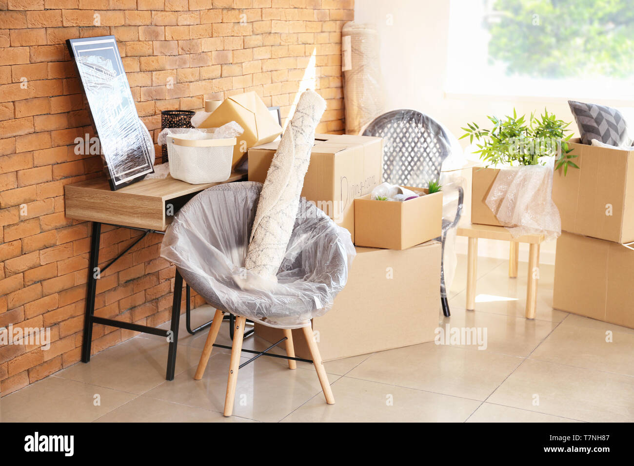 Interior items and packed carton boxes in room. Moving house concept ...