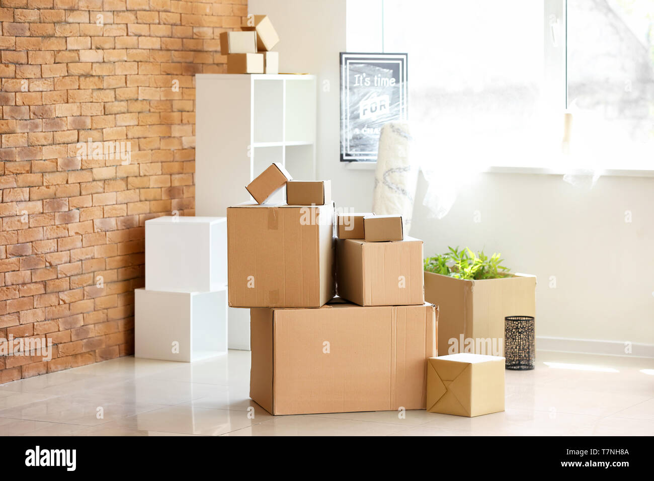 Carton boxes and interior items in room. Moving house concept Stock ...